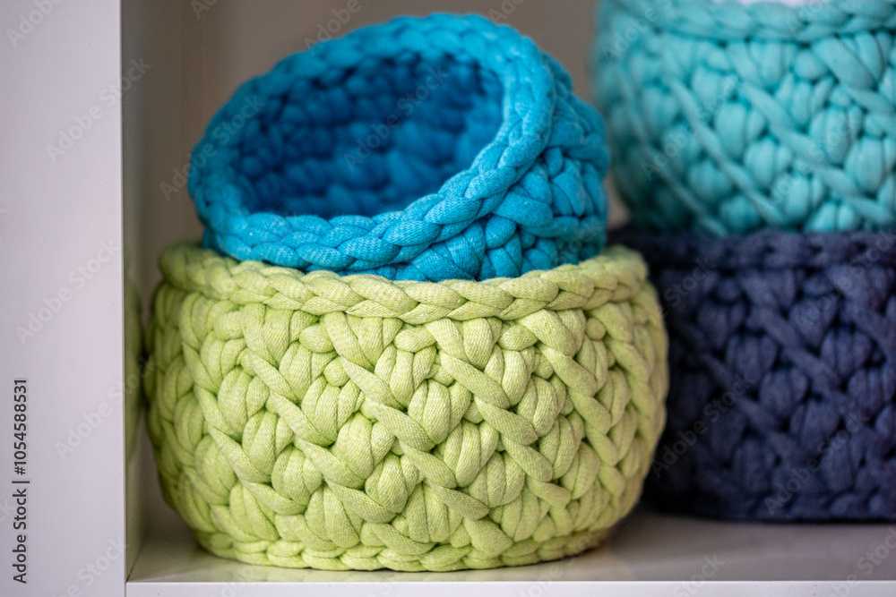 Colorful woven baskets in varying sizes displayed on a shelf, enhancing ...