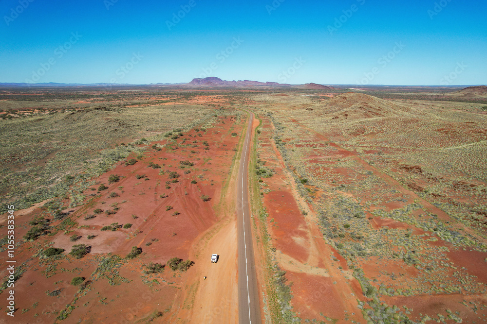 Aerial view of a remote desert landscape with a winding road and a ...