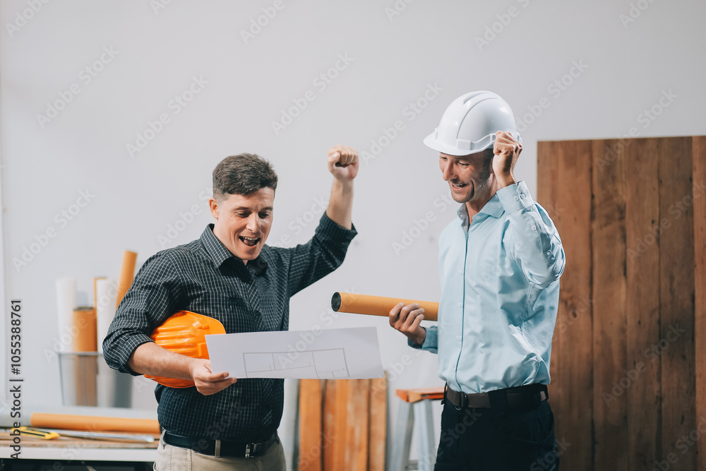 Team Engineers with draft plan of building on constructing site ...