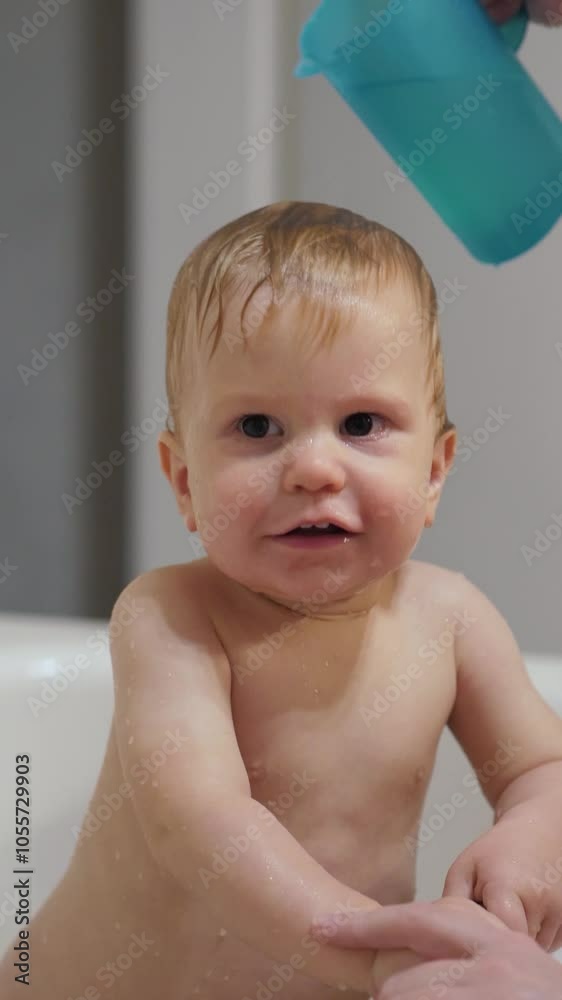 Vertical video of happy baby getting his hair washed in bath, which ...