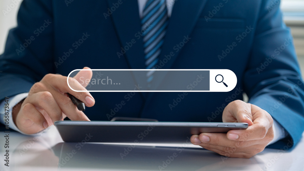 businessman in a suit using a tablet with a virtual search bar overlay ...