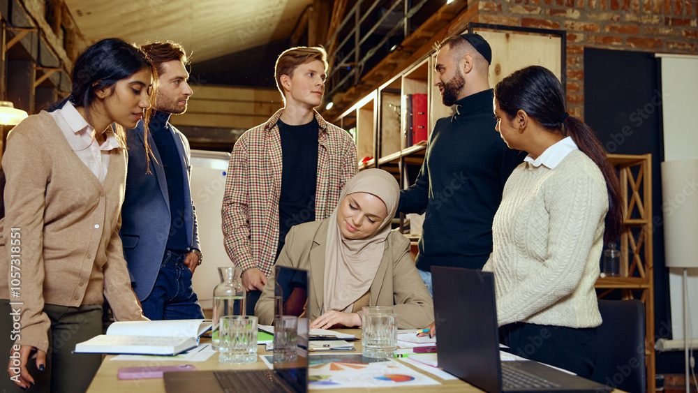 Multicultural team discussing ideas around table, involved in ...