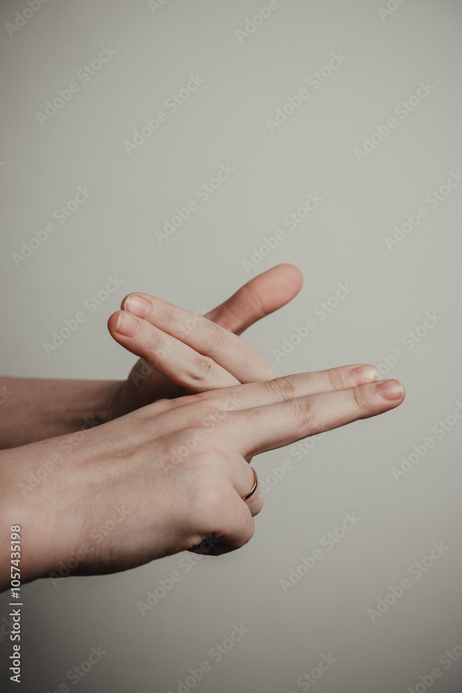 Two human hands making delicate and expressive gestures against a plain ...