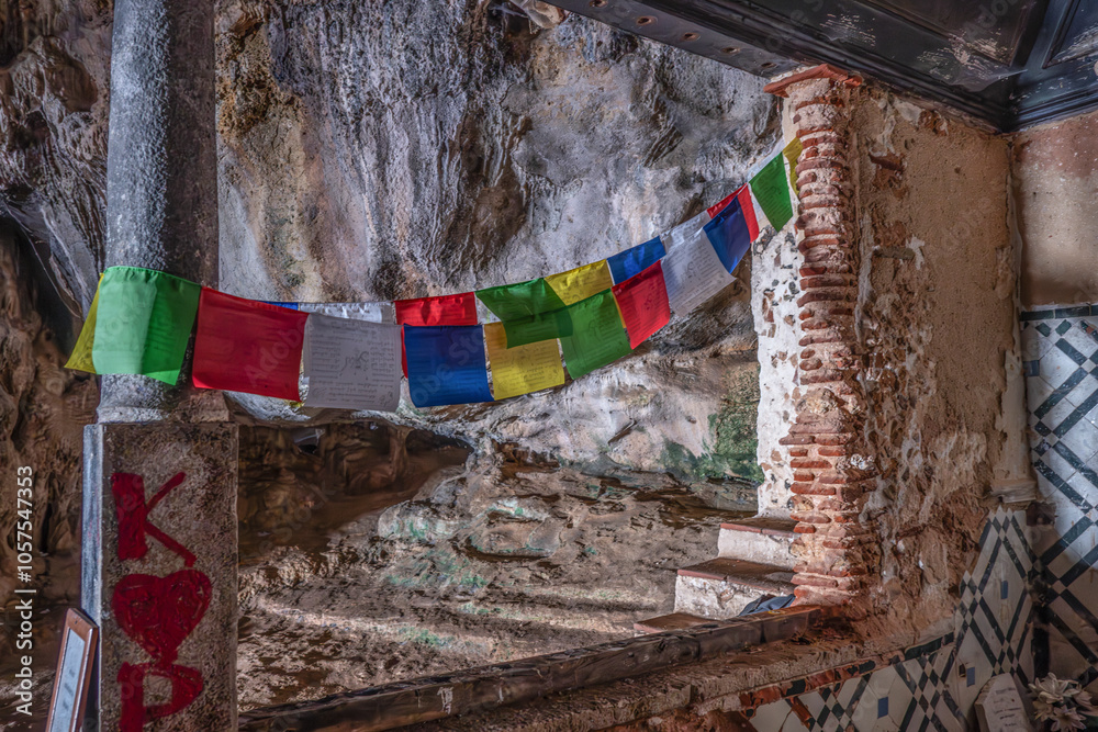 Buddhist prayer flags and grafitti in the historic Santa Margarida cave ...