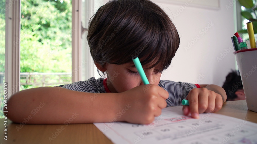 Young boy intently focused on a drawing activity, coloring with ...