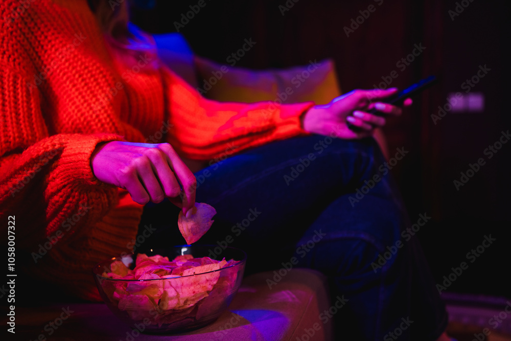 Cropped photo of young woman remote controller eat chips dressed orange ...