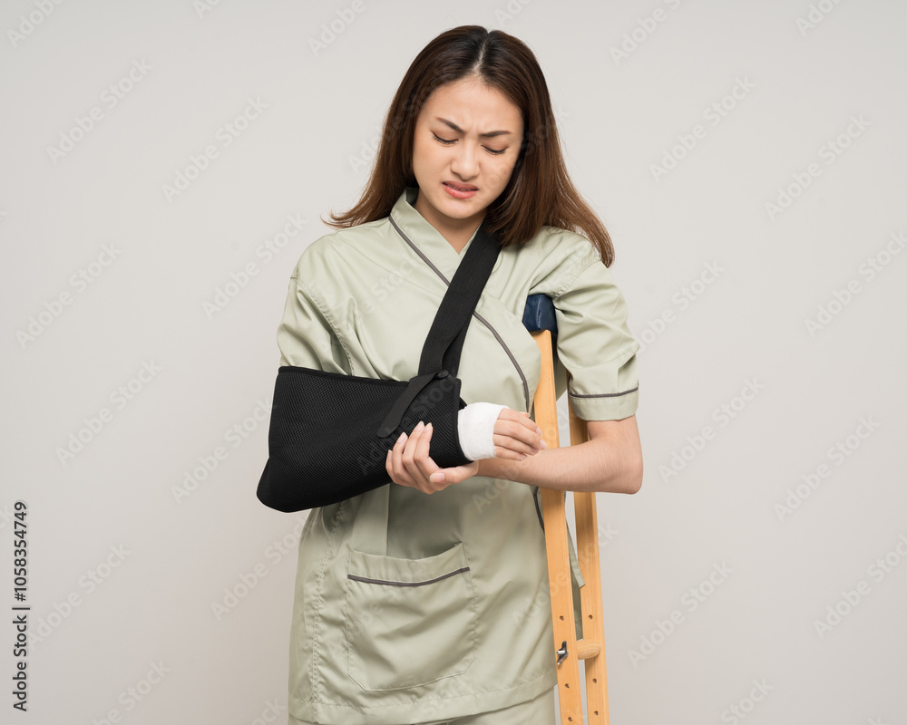 Depressed upset woman suffering from pain. Broken arm. Asian woman put ...