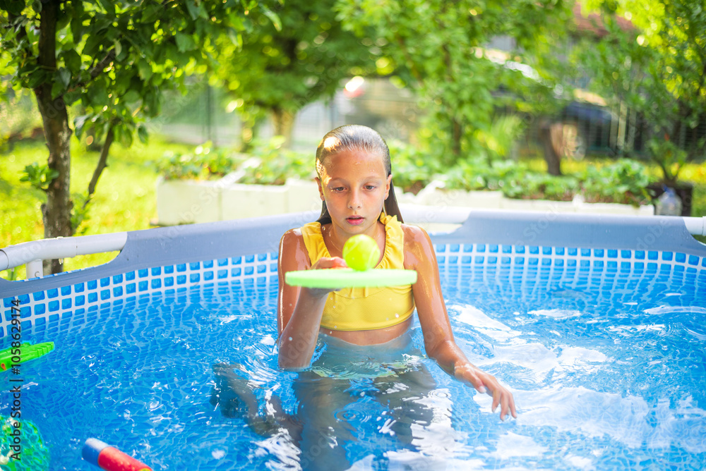 Girl playing with ball and racket in a backyard swimming pool Stock ...
