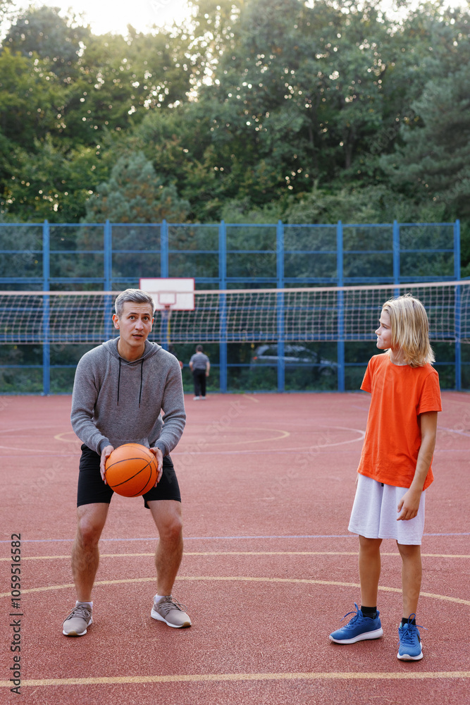 Father teaching son how to perform set shots on basketball court Stock ...