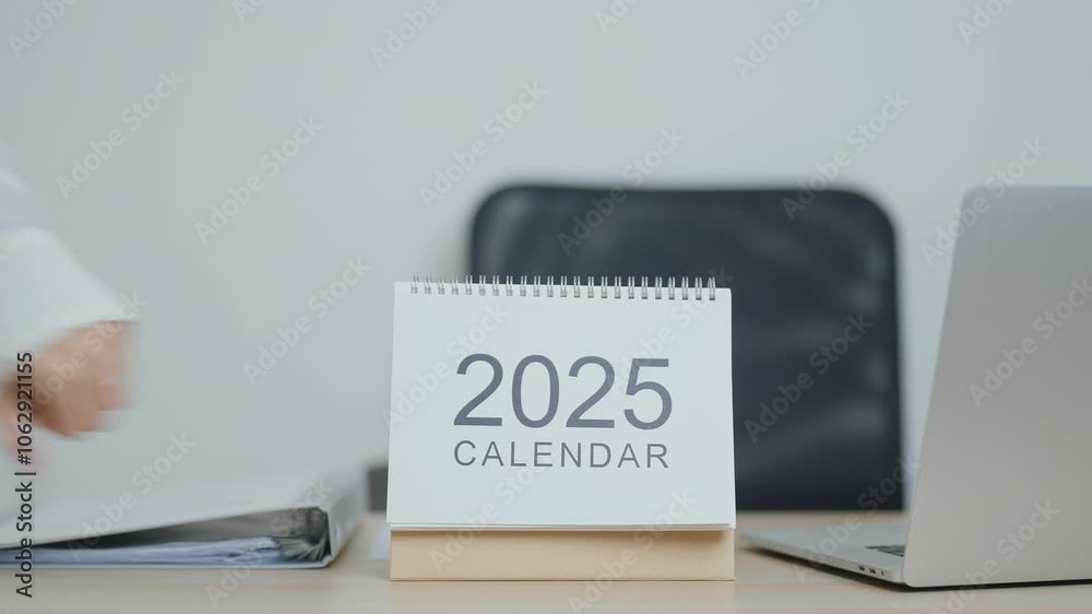Business woman change 2025 Year Calendar on table with laptop computer ...