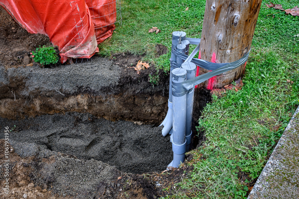 PVC pipes temporarily duct taped to a wood utility pole to hold them in ...