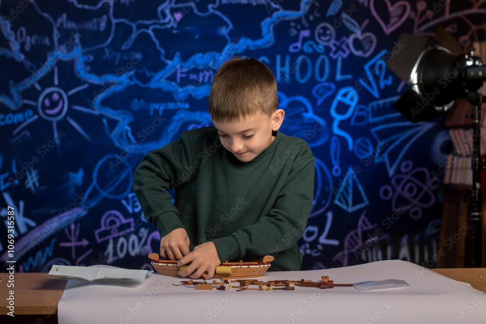 Boy working on a model ship with an instructional manual, engaging in a ...