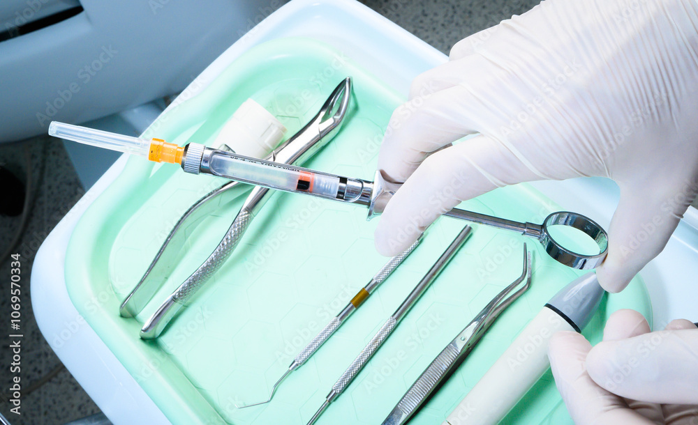 Tray of dentistry elements. Hand of dentist taking anesthesia syringe ...