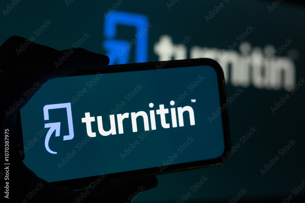 Silhouette of Hand Holding Phone with Turnitin Logo in Front of ...