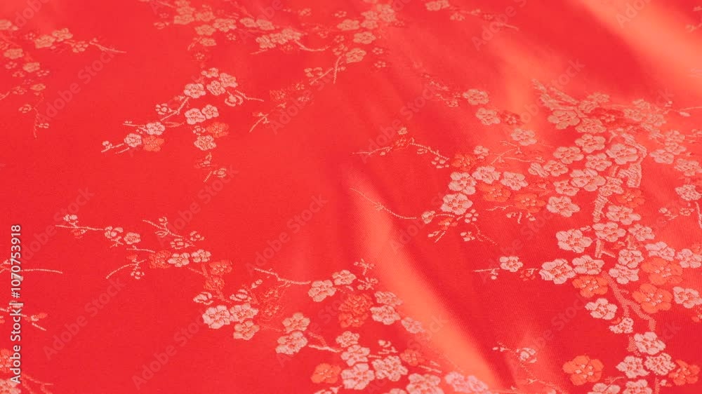 Lustrous red silk rose shade textile fabric background with floral ...