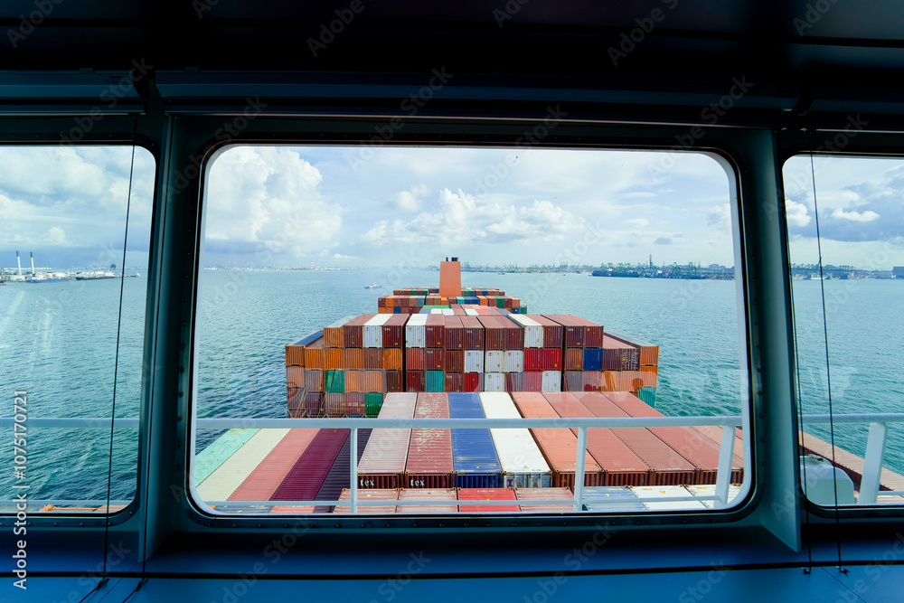 Cargo ship's navigation bridge window view showing a stack of colorful ...