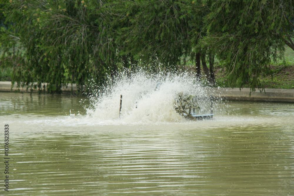 water wheel hydro power generator in pond with pond edge trees. Rotary ...