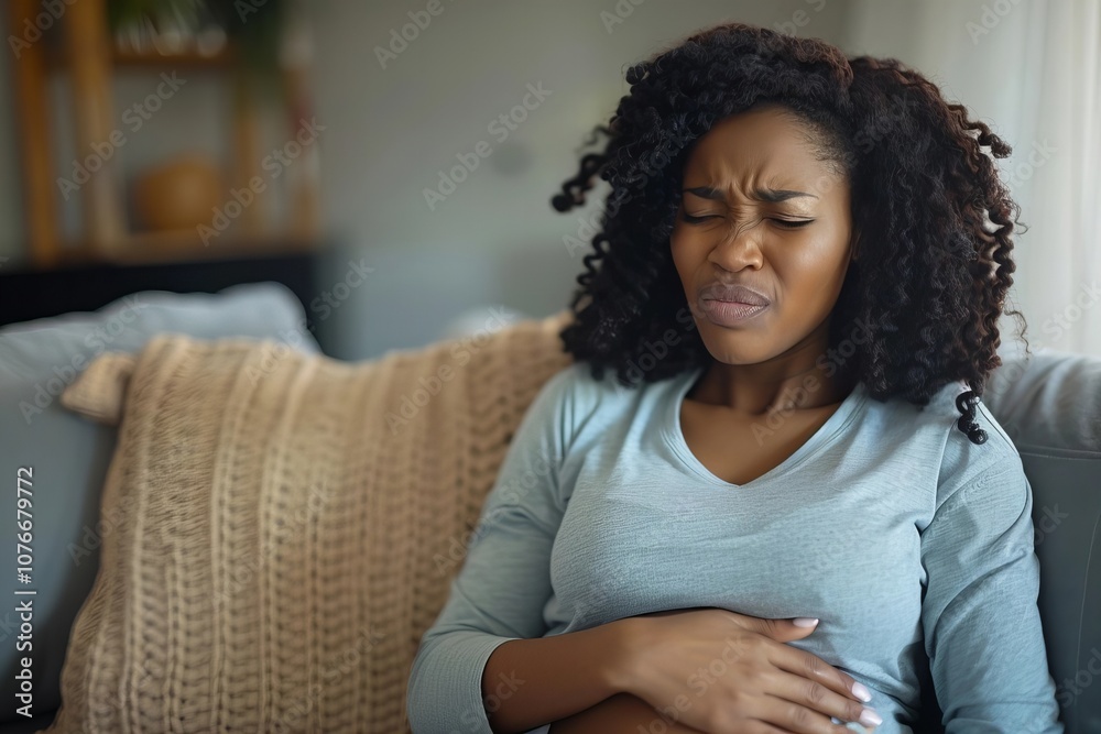 A young Black woman experiences stomach pain, digestion issues, and ...
