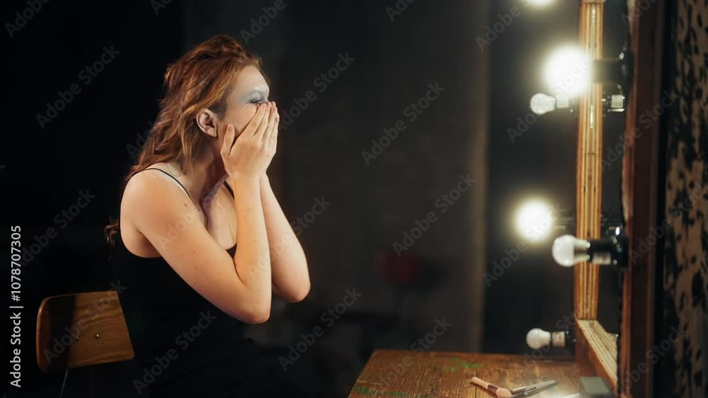 Mad woman with split personalities smearing makeup on face and neck and ...