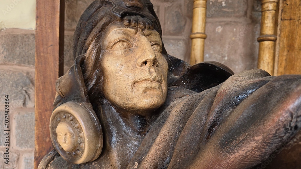 A wooden painted statue representing an ancient Inca man with a round ...