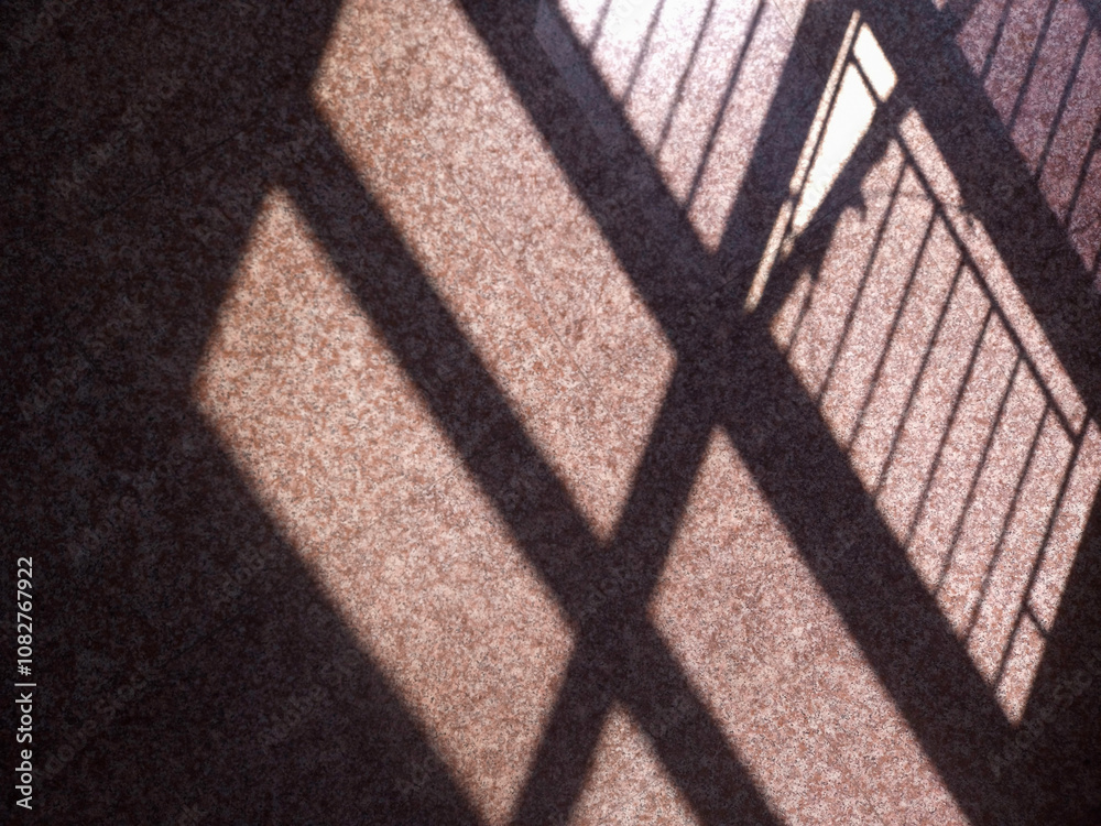 shows the shadow of a window with bars cast onto a tiled floor. The ...