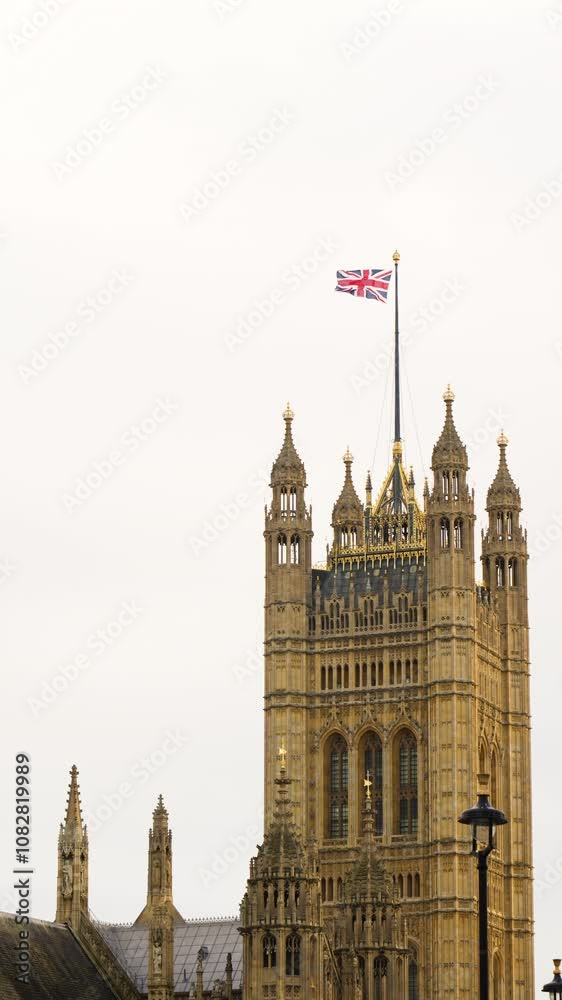 Detailed view of a historic British tower with the Union Jack flag ...