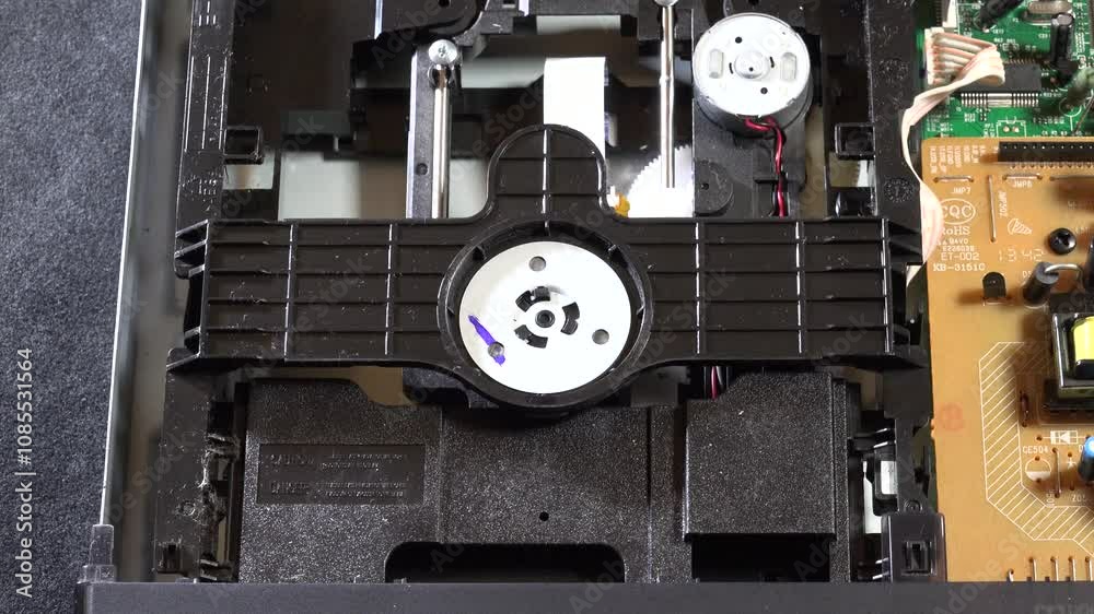 An open DVD player shows its internal components and circuitry, with ...