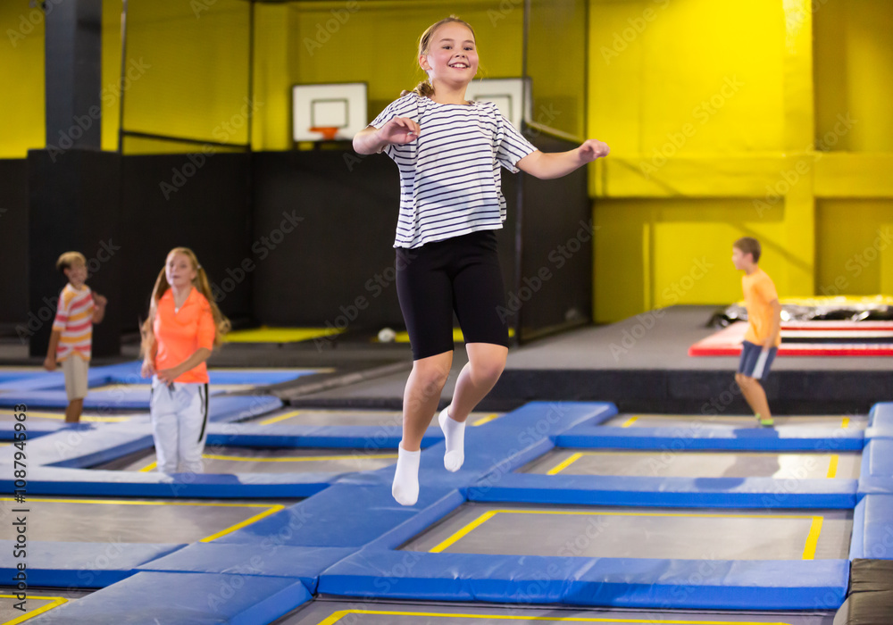 Expressive carefree tween girl having fun during free-jumping session ...