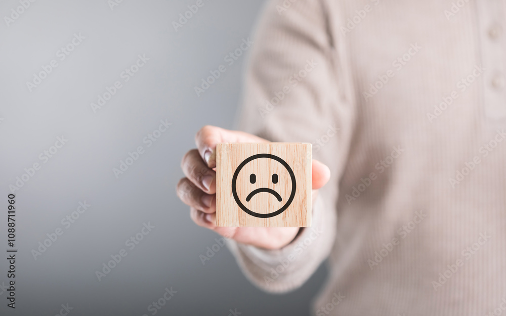 Poster Man holds a wooden block with a sad face, symbolizing feelings ...