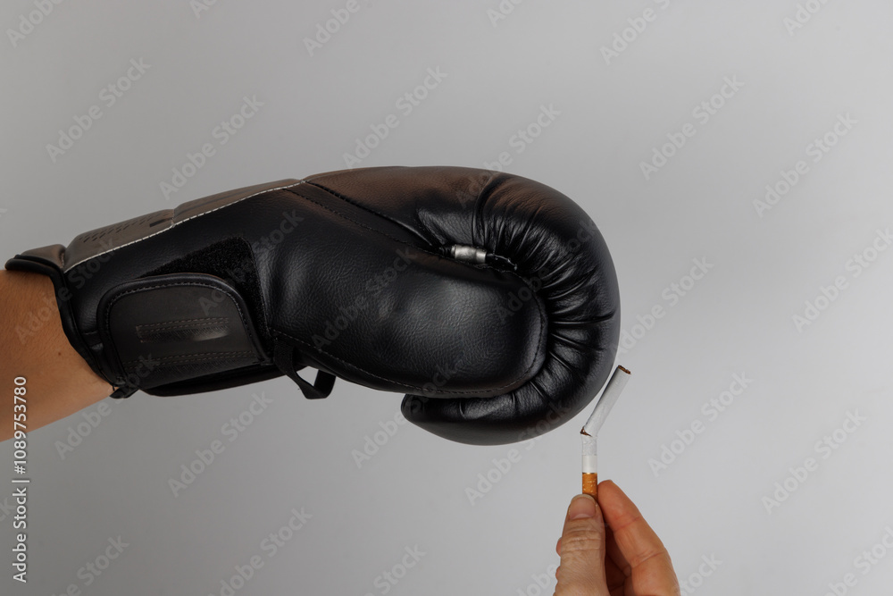 Breaking a cigarette with a punch thrown with a boxing glove foto de ...