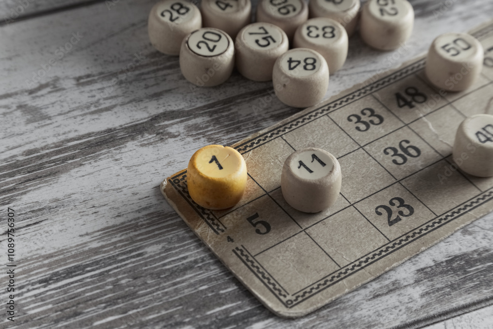 A bingo token with the number one on a playing card on an old worn ...