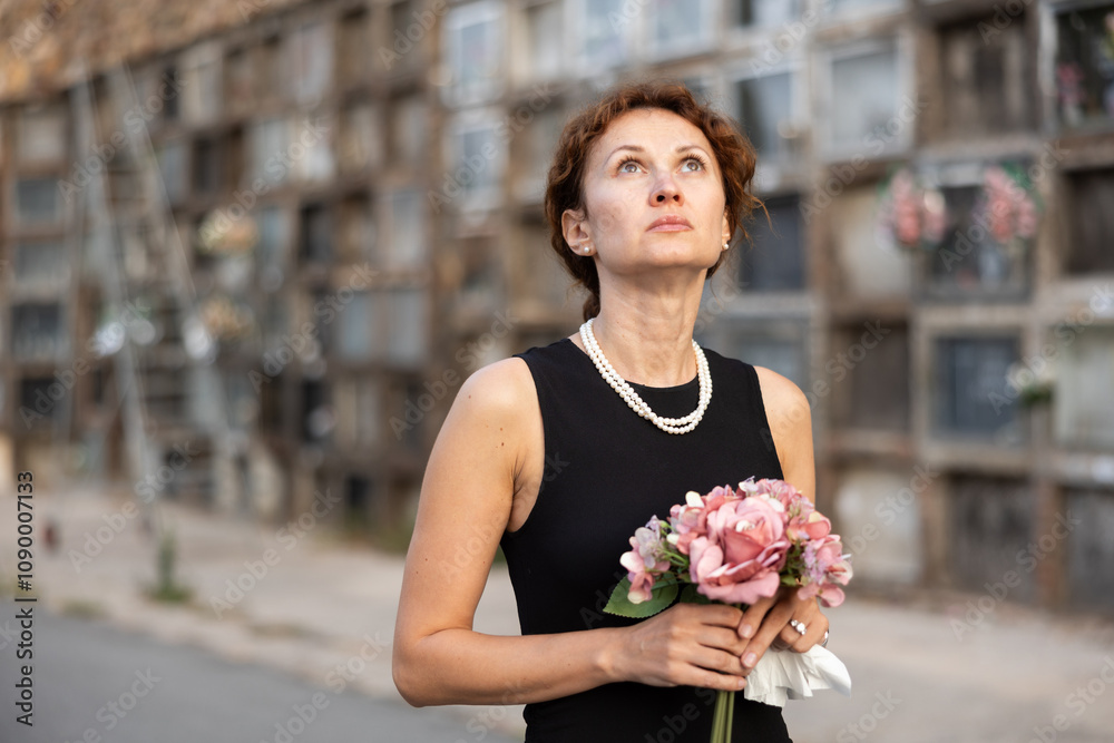 Sad woman in black mourning dress and pearl necklace standing in front ...