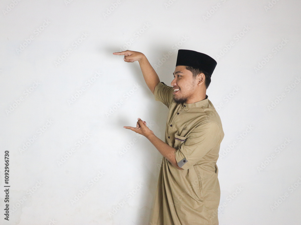 Smiling friendly handsome young Asian Muslim man in Arabic costume ...