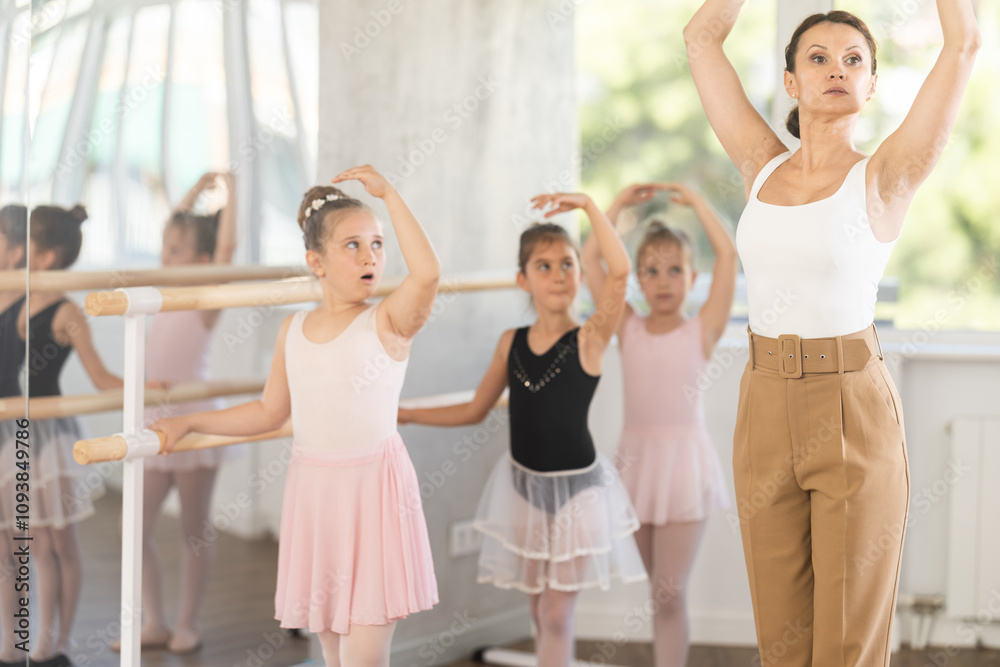 During lesson in choreography class, girls repeat movements of teacher ...