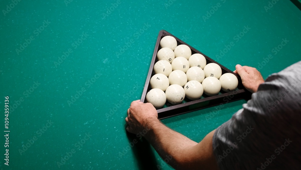 The player places the triangle with billiard balls in the designated ...