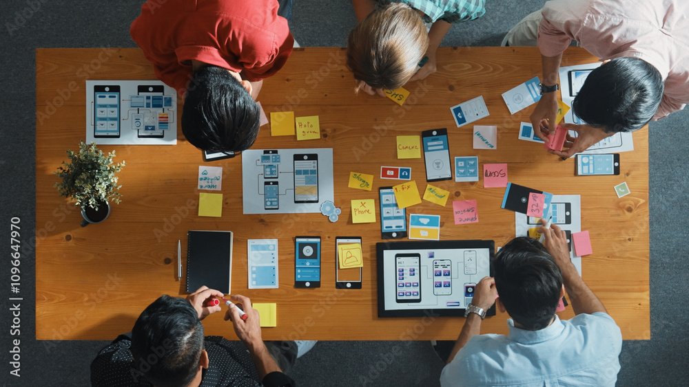 Top down view of business team writing idea on sticky note while ...