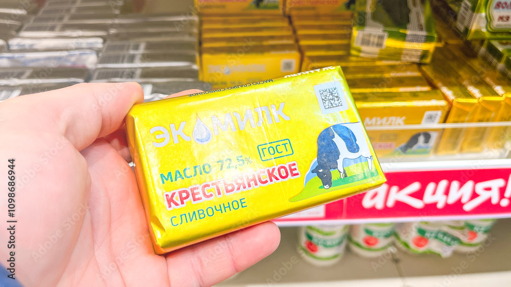 Moscow November 24 2024, A person is holding a yellow bar of butter in ...