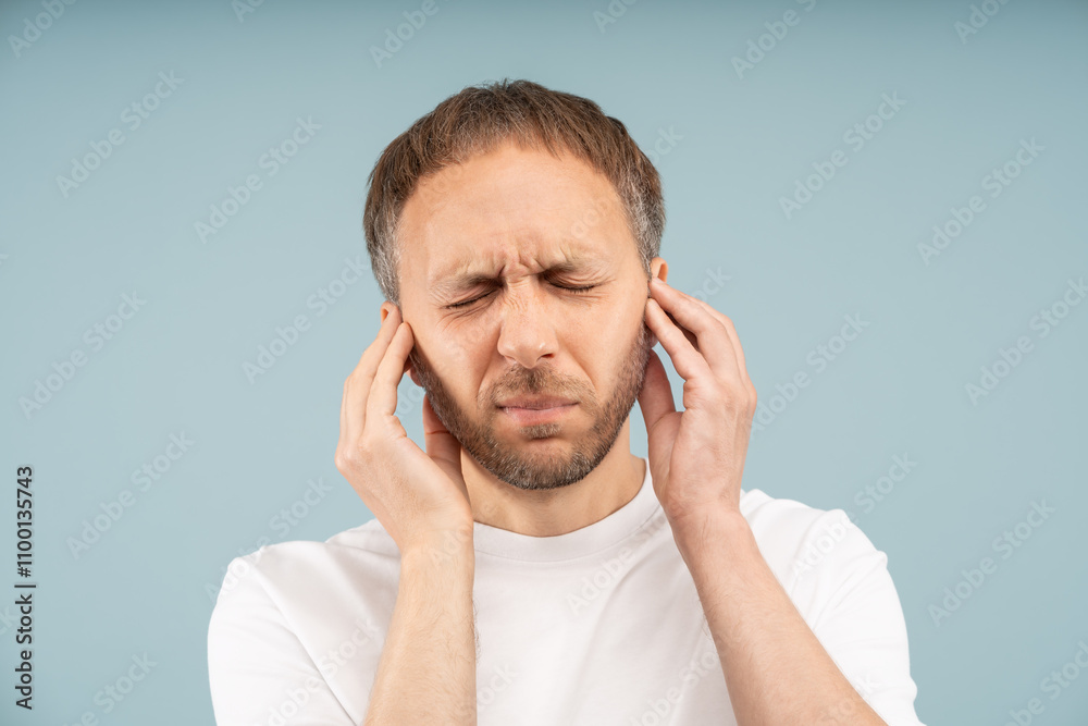 Neurological issues. Frowning man suffers discomfort persistent ringing ...