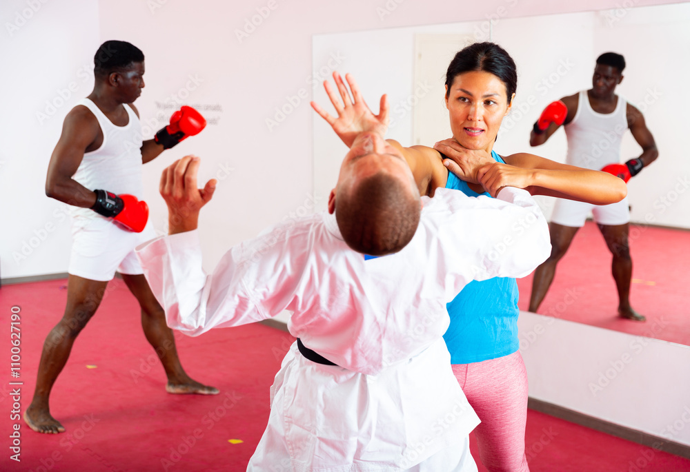 Oriental woman training chin strike with her trainer. African-american ...
