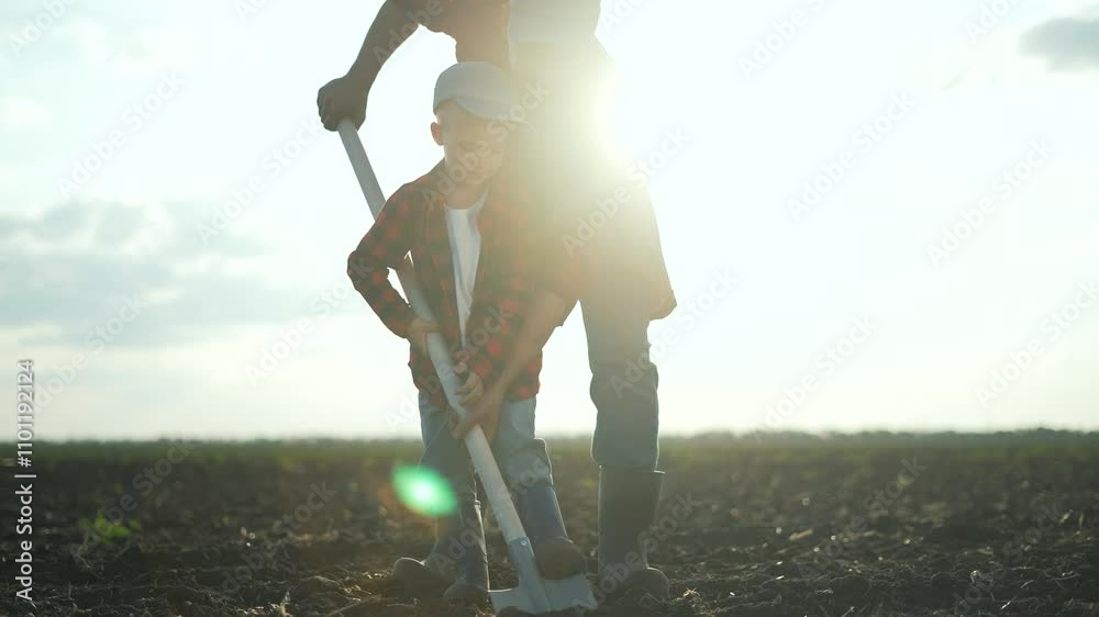 Father and son work in agriculture. Farmer teaches son to dig soil with ...