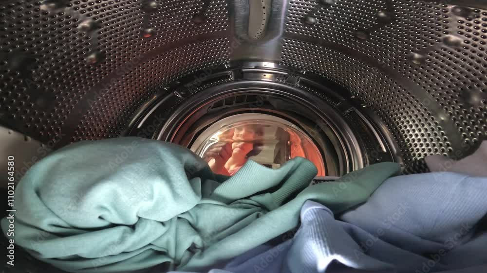 Perspective from within washing machine drum, showing colorful clothes ...