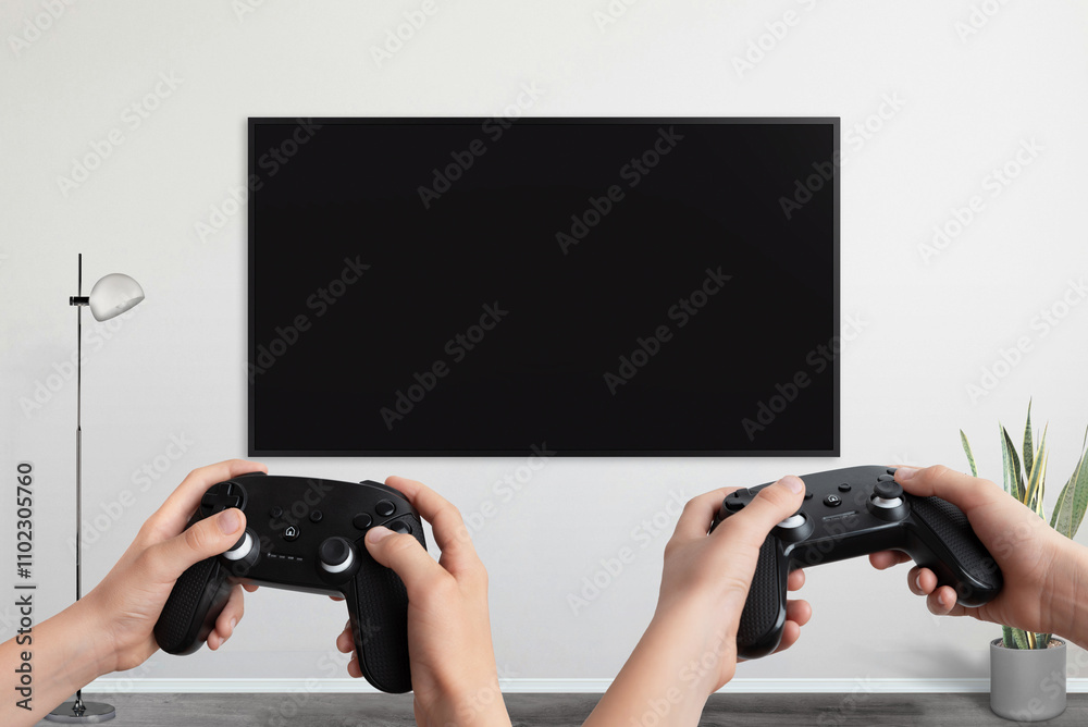Two players holding gamepad in front of a TV with a blank screen ...