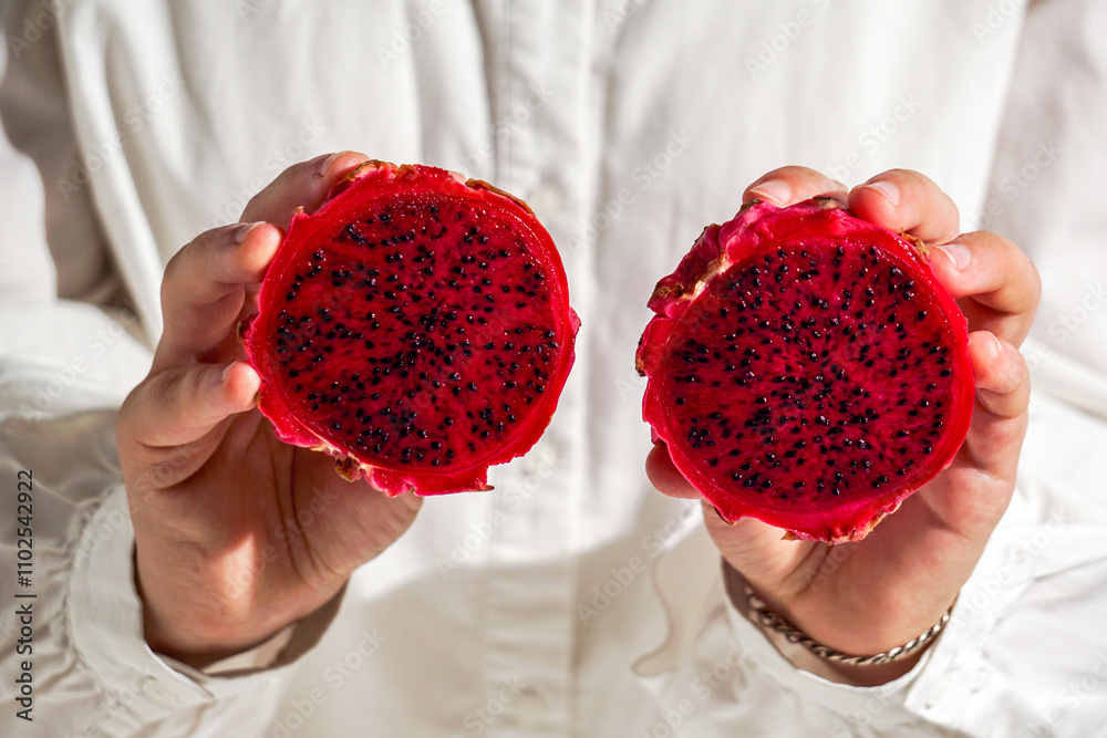 dragon fruit, also known as pitaya, cut open pink magenta-colored flesh ...