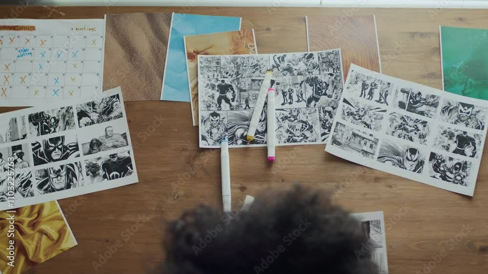 Top down view shot of Black female illustrator using blue highlighter ...