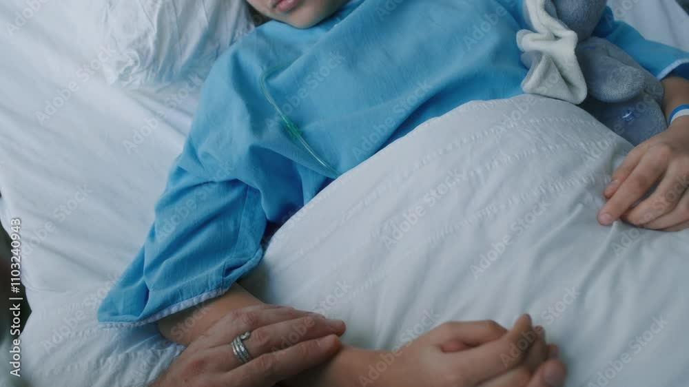 Tilt shot of unconscious girl with nasal prong lying in hospital bed ...