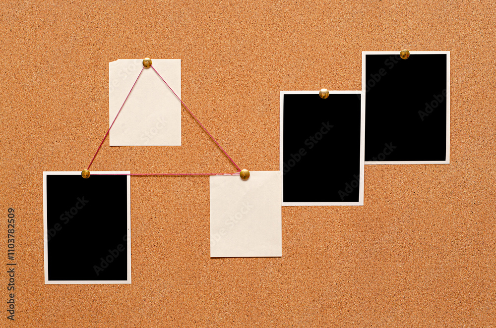 Blank paper notes and an empty photo are pinned to a cork board. The ...