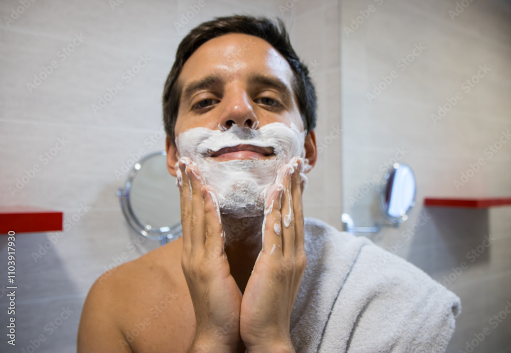 Close-up of a smiling young man with a towel slung over his shoulder ...