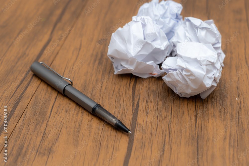 Writing concept - crumpled up paper wads with a sheet of white paper ...