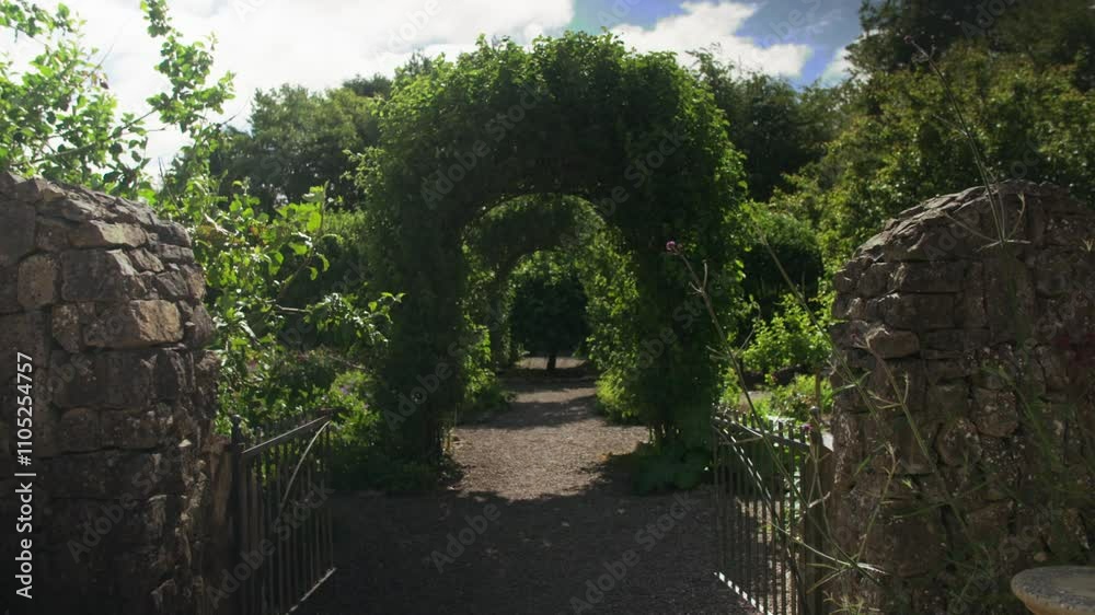 Video of a garden entrance with a small gate supported by brick walls ...