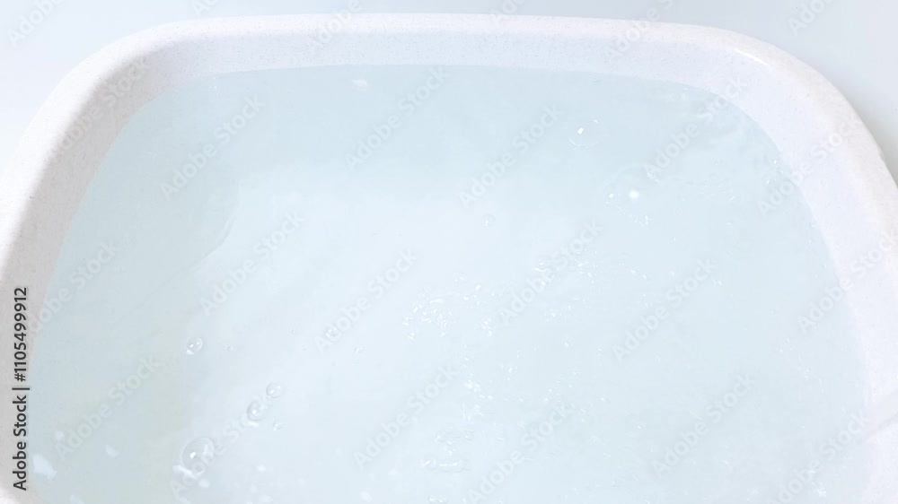 Pour water into a plastic container, basin. Pour running water into a ...